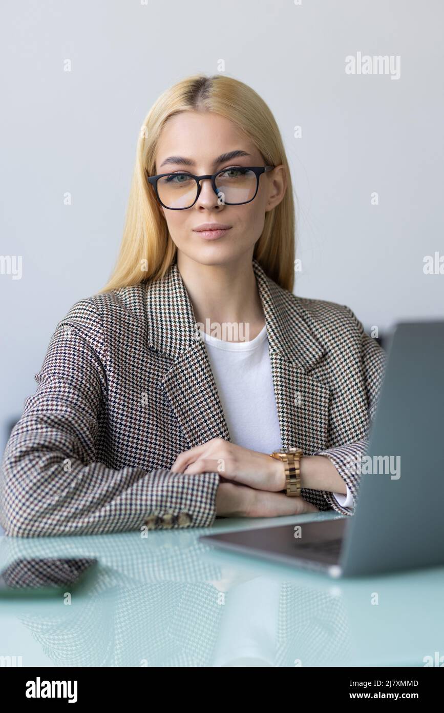 Image of young beautiful joyful woman smiling while working with laptop ...