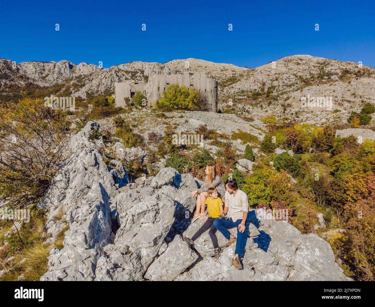 Happy family on the background of Collapsing tower of fortress Kosmac ...