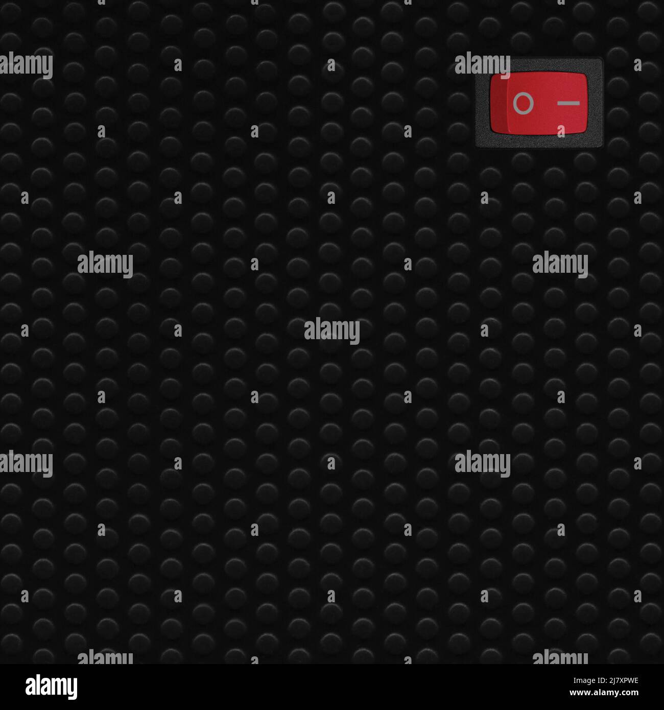 Red rectangle rocker power switch in on position, black abstract dot ...