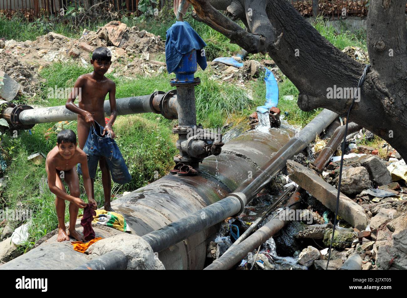 Kids cool down in the water from a pipe draining near a road in New ...