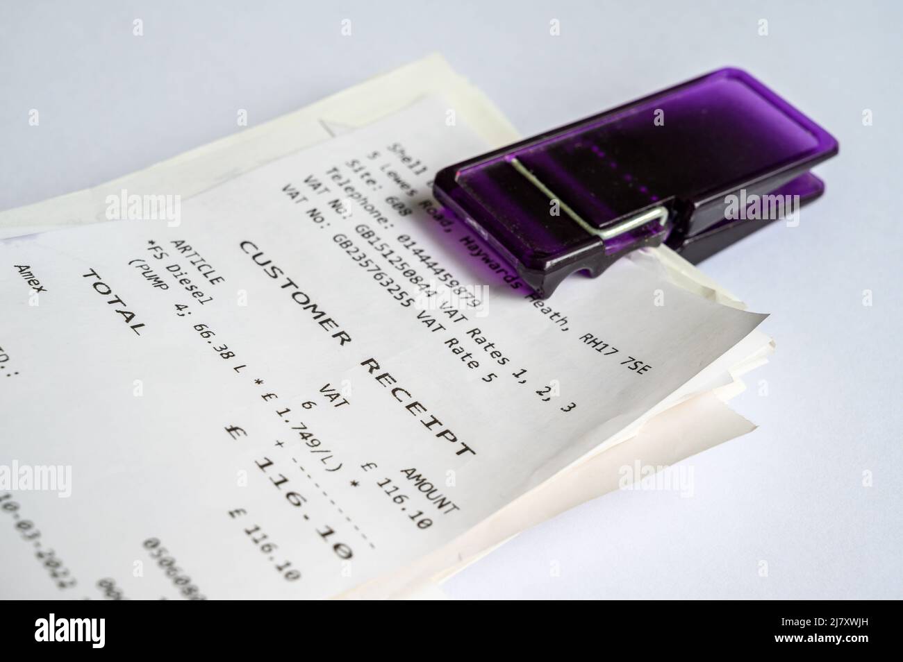 Closeup of a pile of credit and debit card receipts held together by a ...