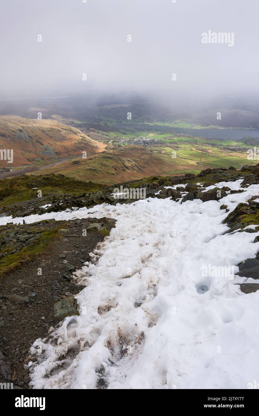 Snow on The Old Man of Coniston with the village of Coniston and ...