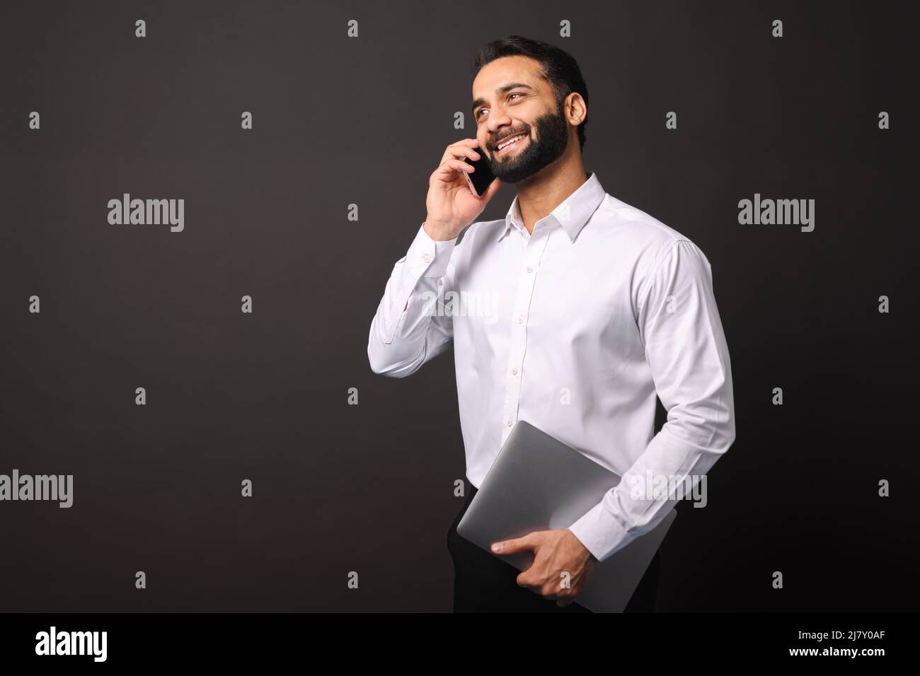 Busy handsome confident bearded Indian man in formal wear talking on ...