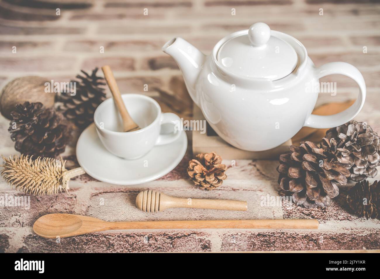 Tea concept, white teapot with white tea cup with dry leaves on wooden ...