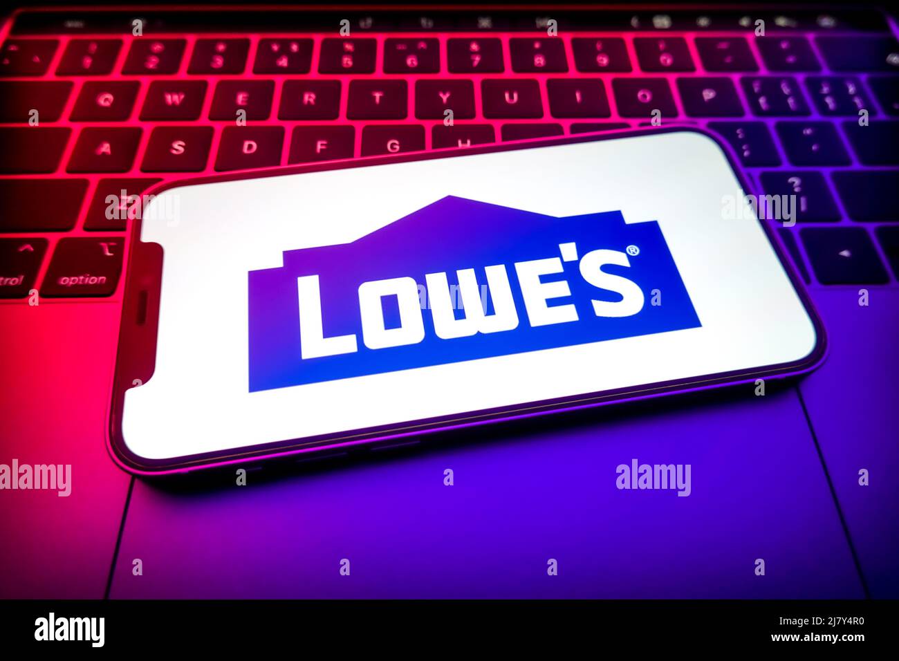 In this photo illustration, a Lowe's logo is displayed on the screen of ...