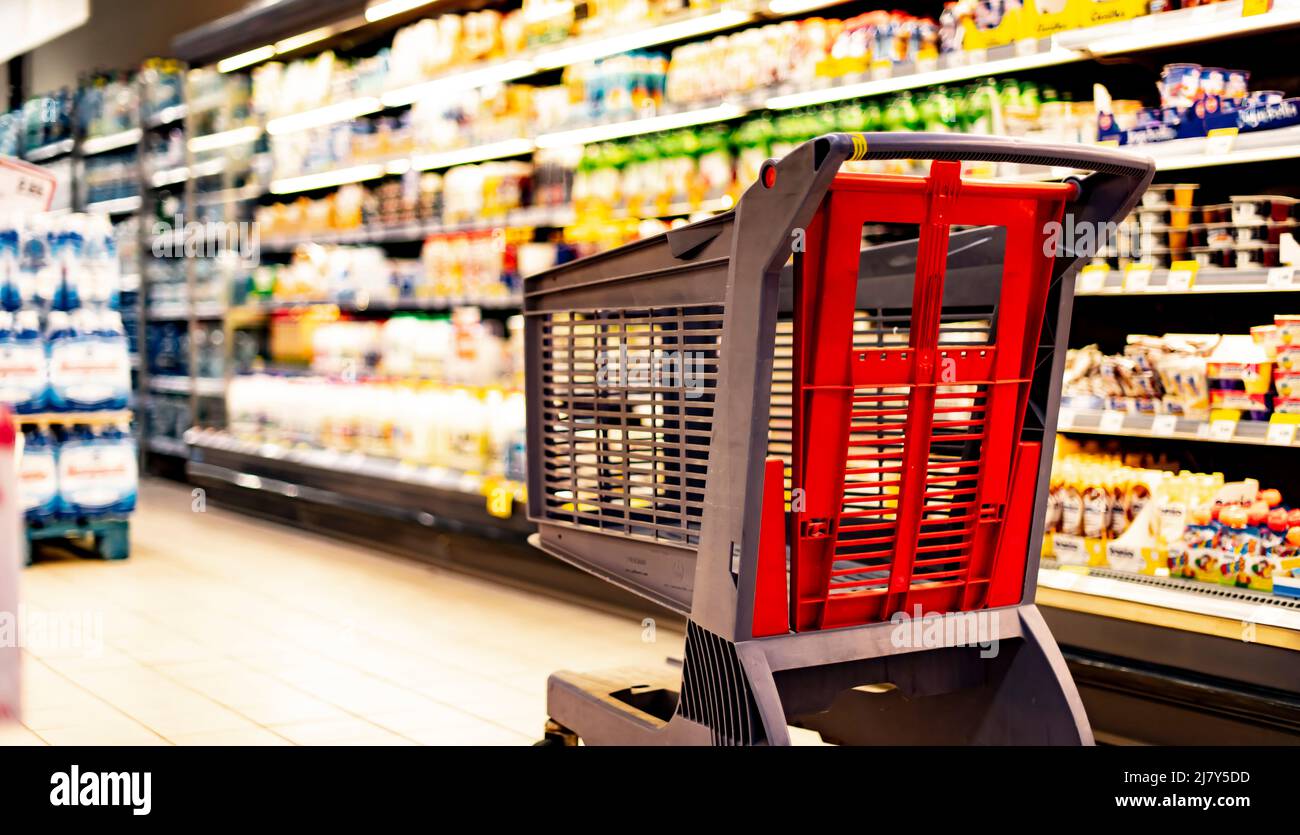 A shopping cart by a store shelf in a supermarket Stock Photo - Alamy
