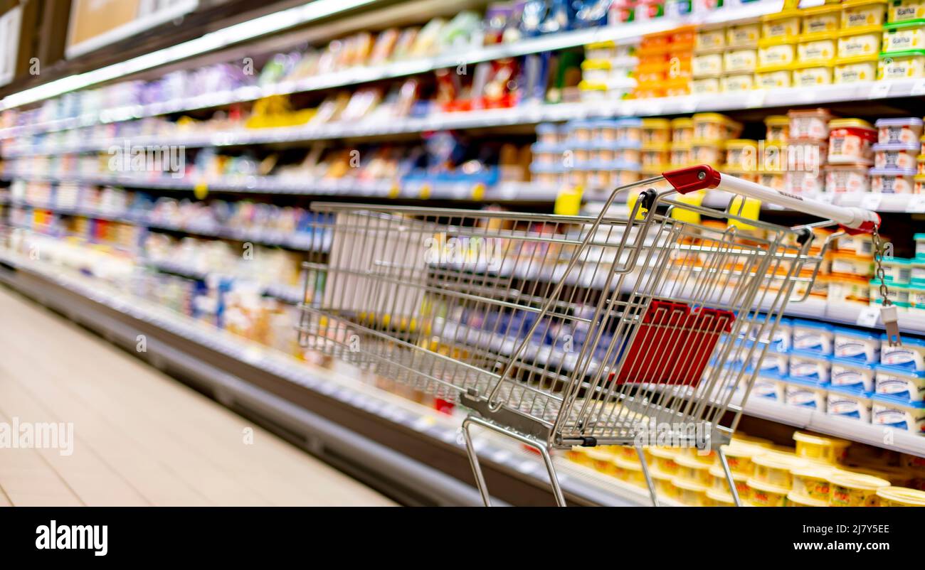 A shopping cart by a store shelf in a supermarket Stock Photo - Alamy