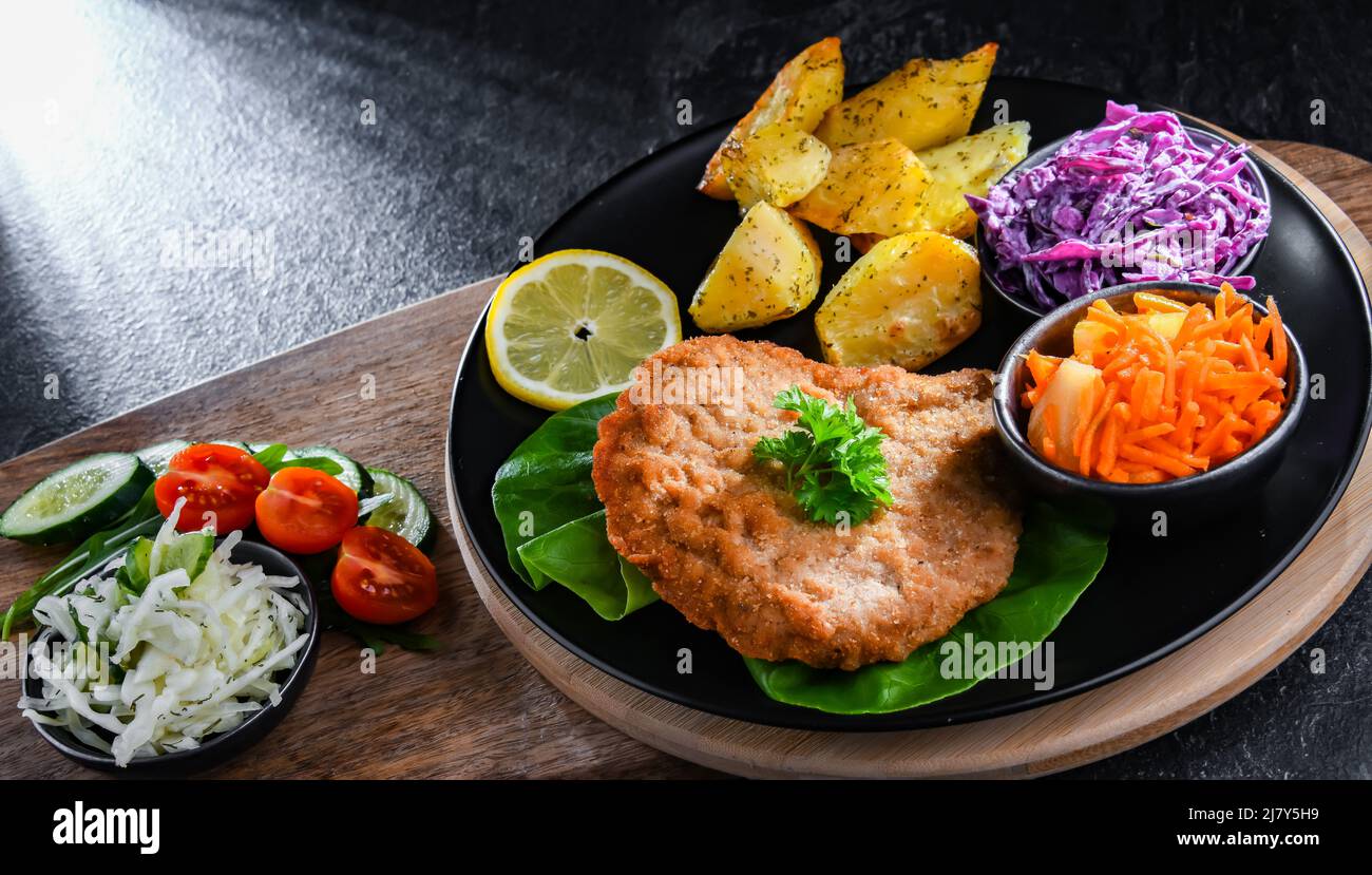 Pork breaded cutlet coated with breadcrumbs with potatoes and vegetable ...