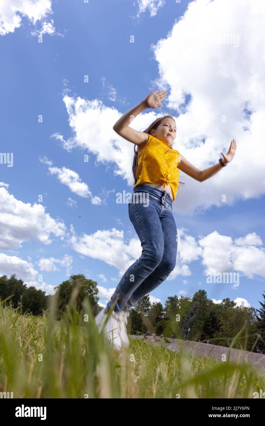 Girl dancing, jumping, doing acrobatics and posing, in a city park on ...