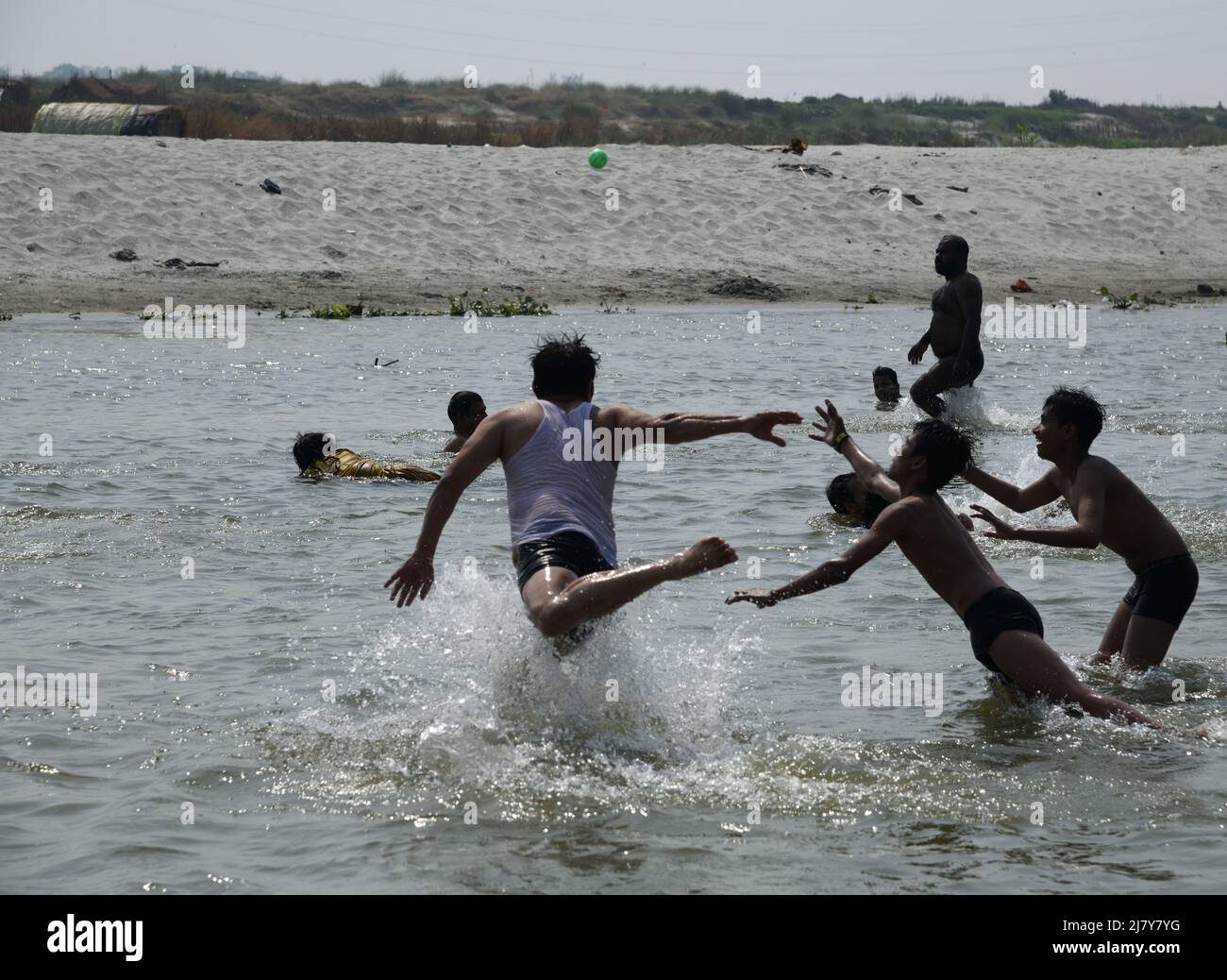 Local boys enjoying to play knee-deep water in the shallow riverbed in ...