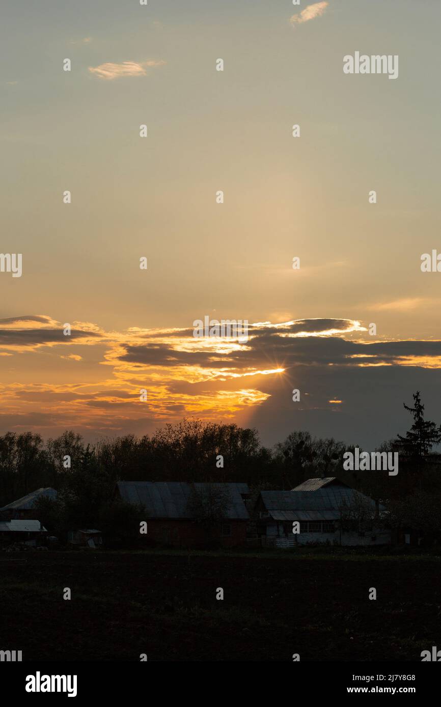 A real sunset sky with beautiful light clouds and sun rays, without ...