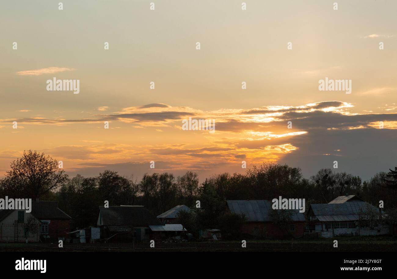 A real sunset sky with beautiful light clouds and sun rays, without ...