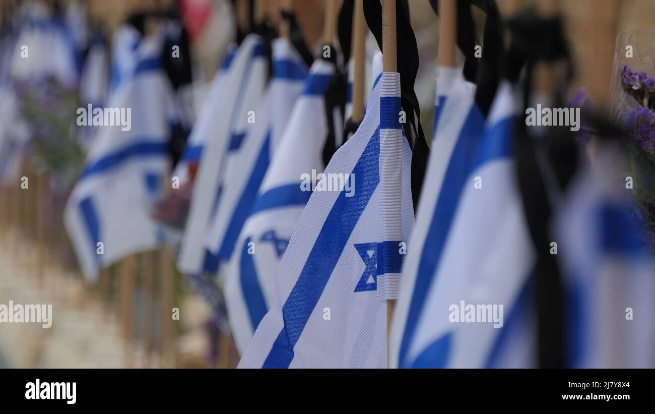Israeli national flags with black mourning ribbons placed over the ...