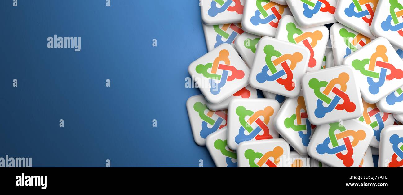Logos of the Web Content Management System Joomla! on a heap on a table. Copy space. Web banner ...