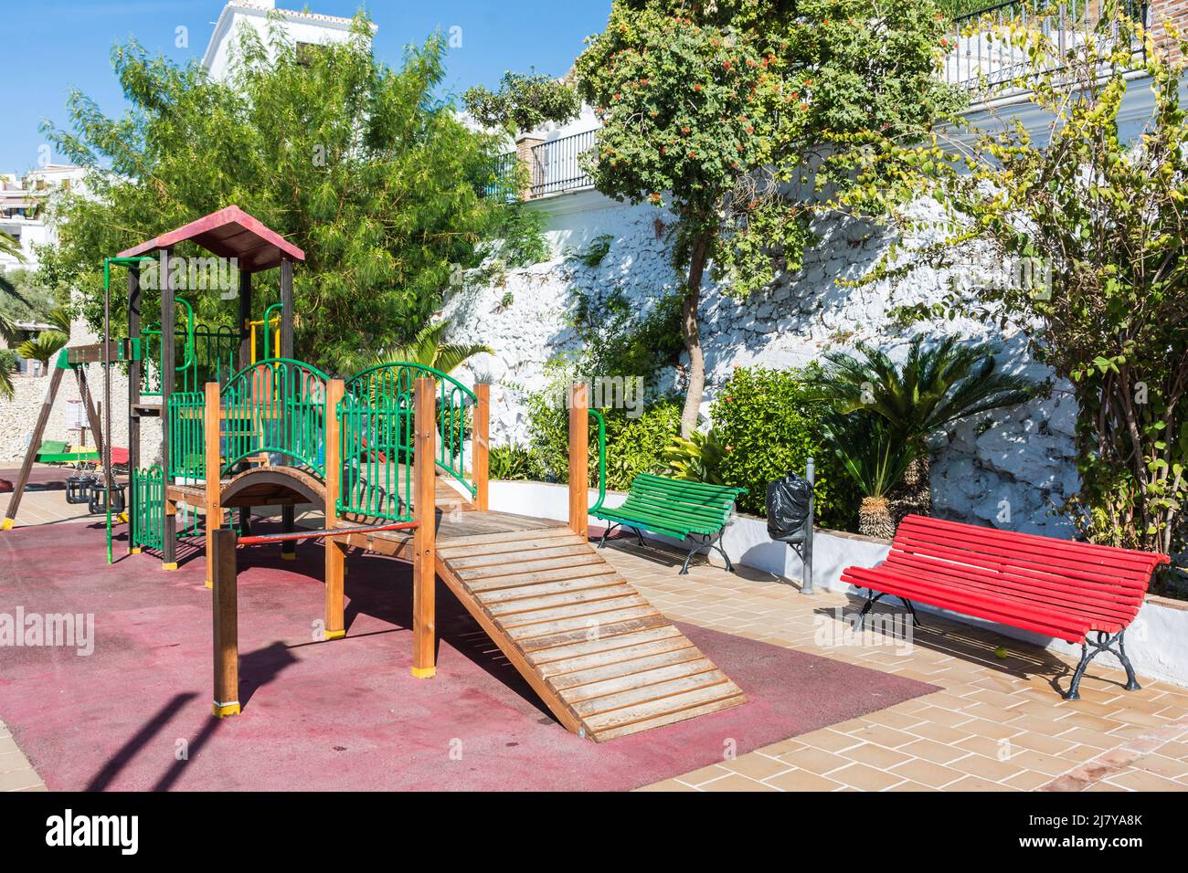 Empty playground with swings, a playhouse and colorful benches Stock ...