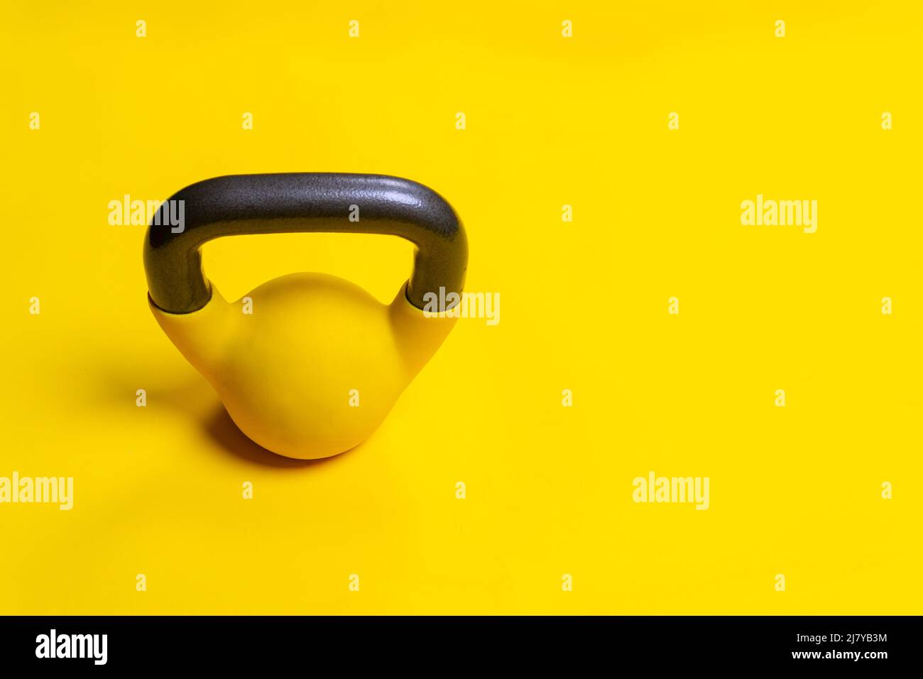 Isolated yellow space kettlebell blue ackground fitness object dumbbell ...