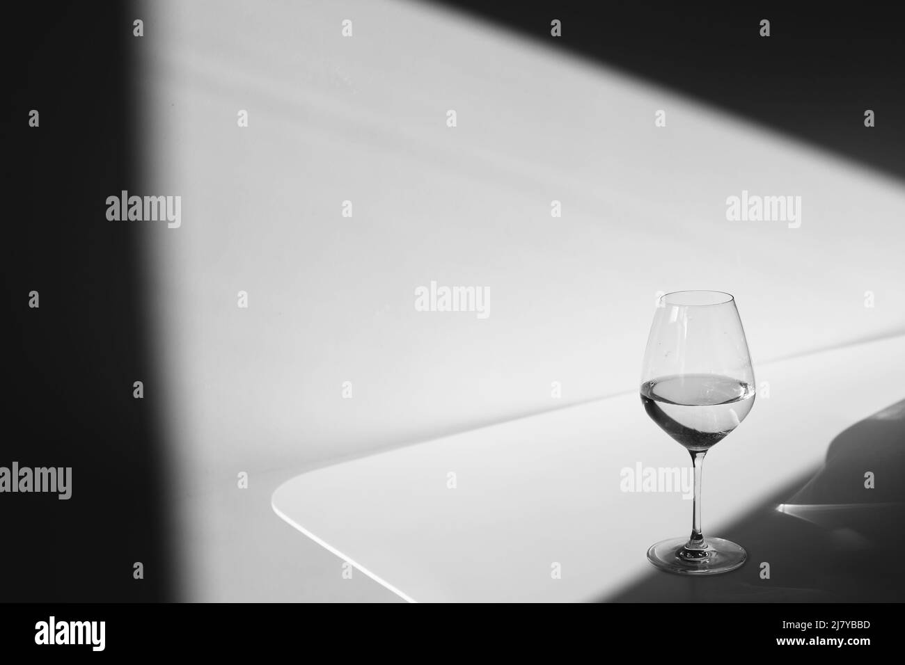 A glass of water on a white background with a shadow. Chiaroscuro from ...