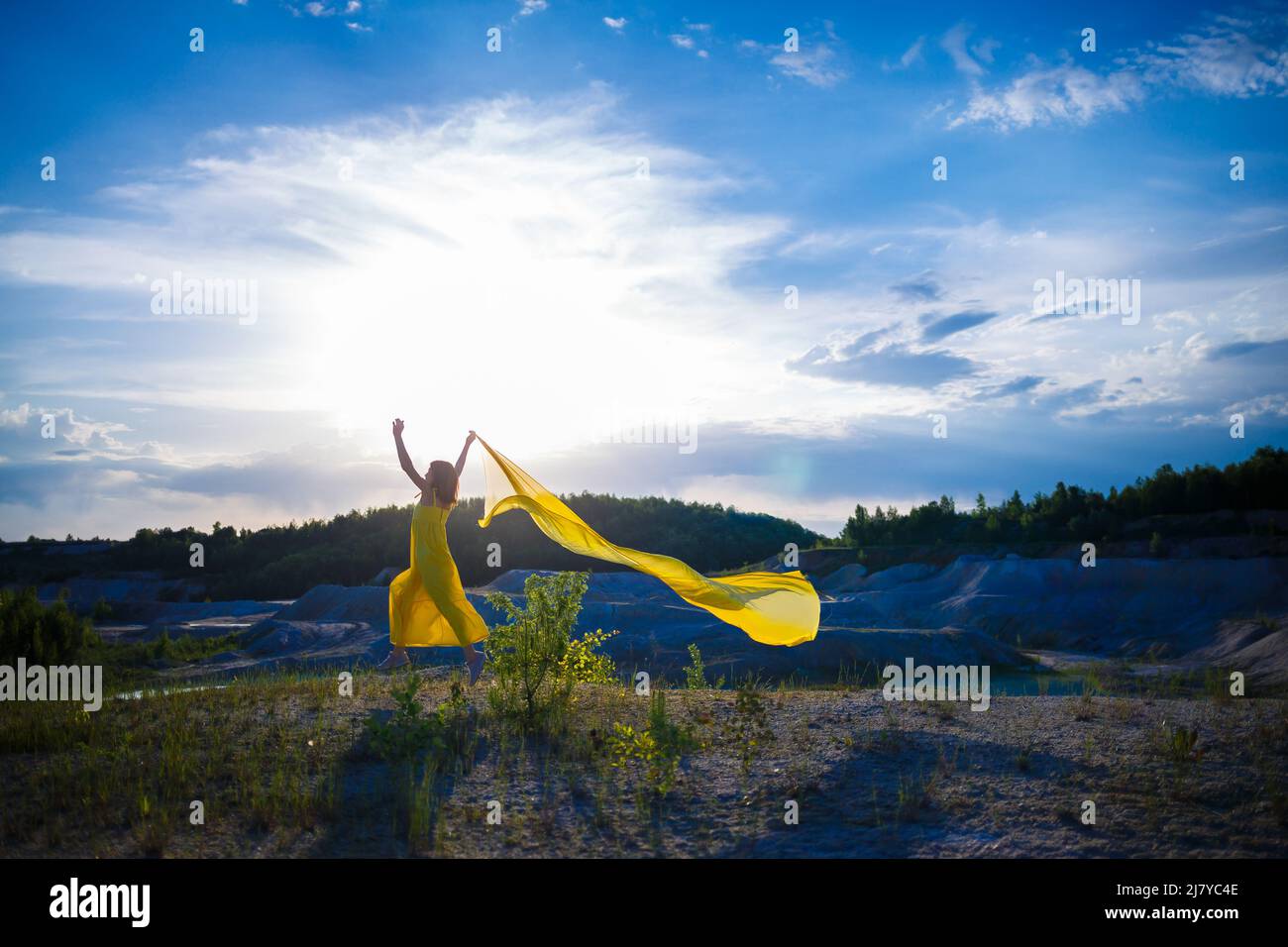 Happy Ukrainian woman running in nature. In a long yellow dress. Symbol ...