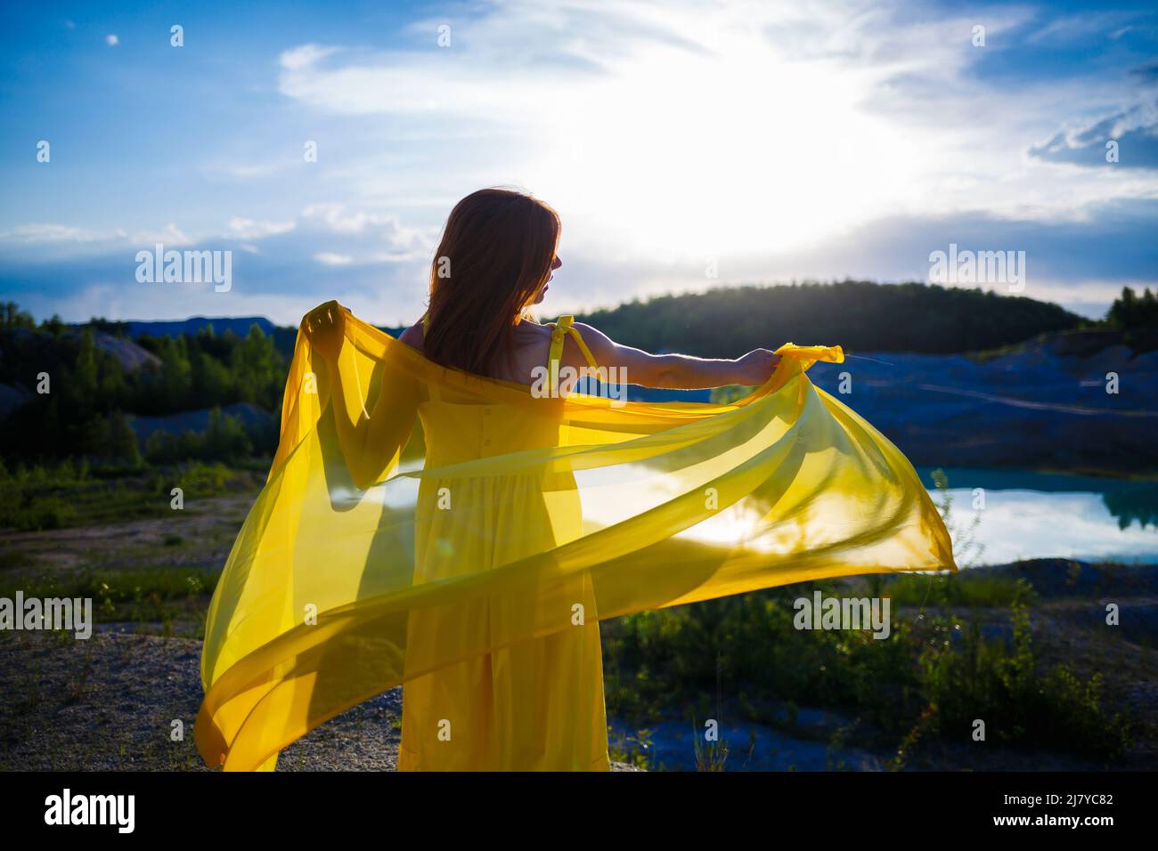 Happy Ukrainian woman running in nature. In a long yellow dress. Symbol ...