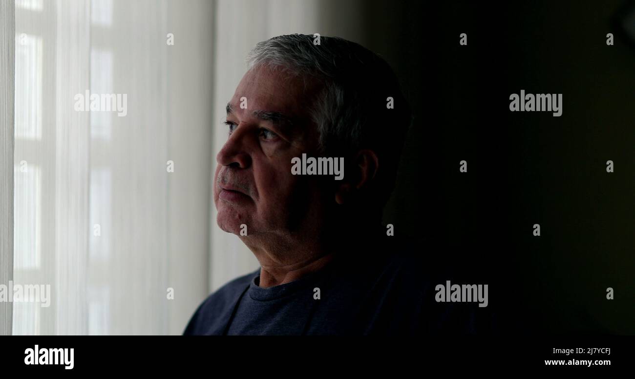 Contemplative 60 year old man looking outside during quarantine Stock ...
