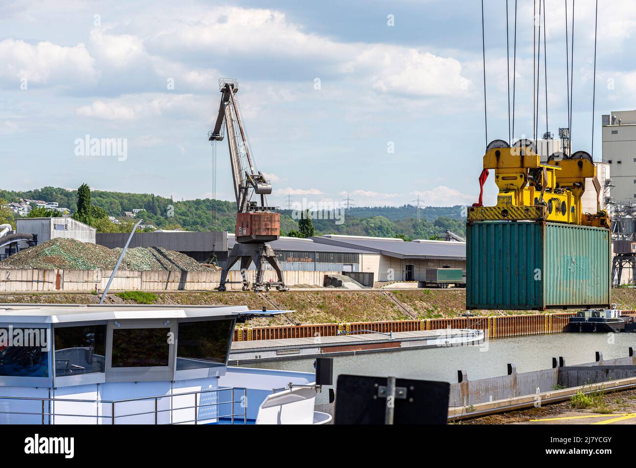 A container gantry crane on a rail loads the container into a barge ...