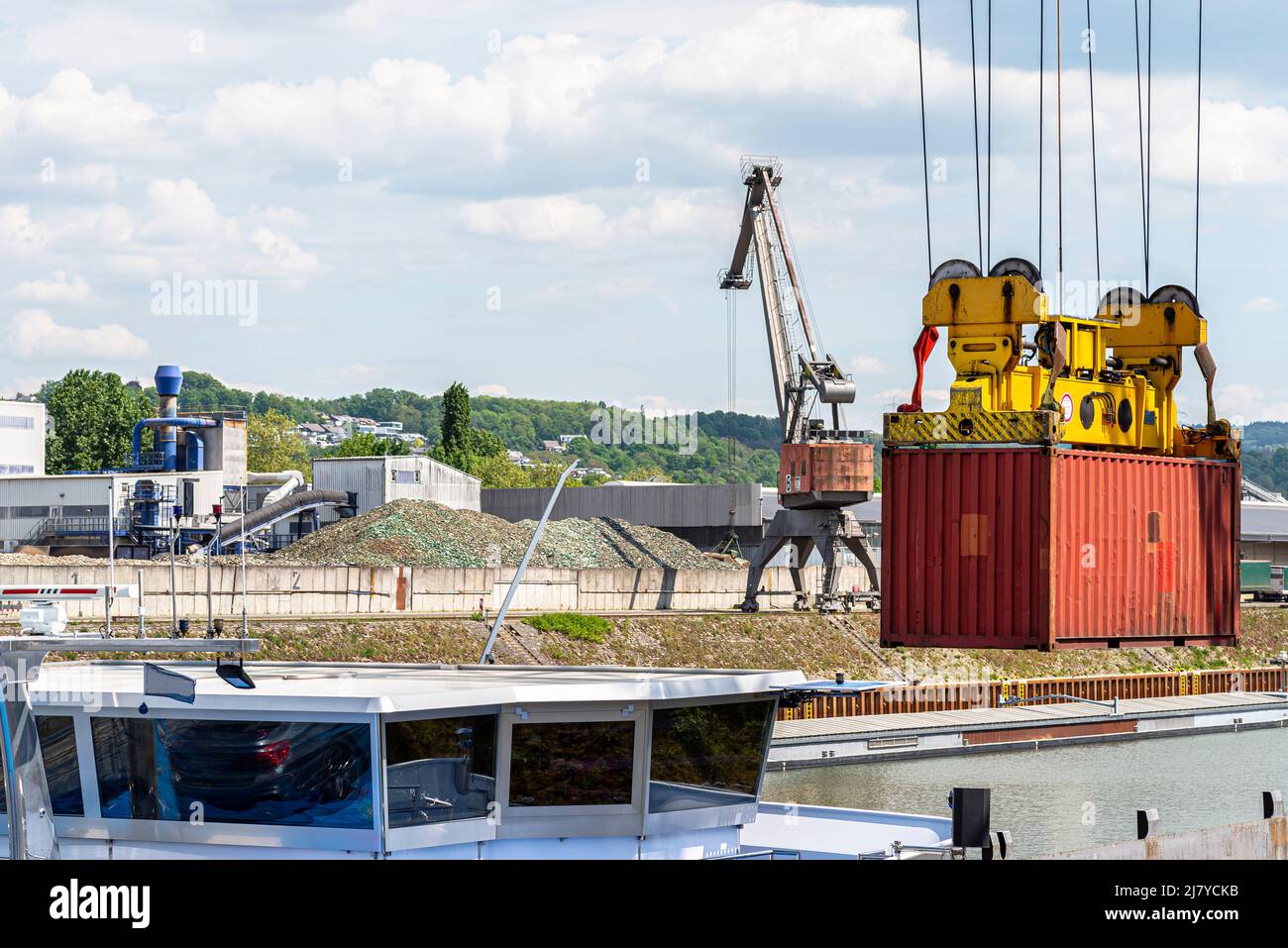A container gantry crane on a rail loads the container into a barge ...