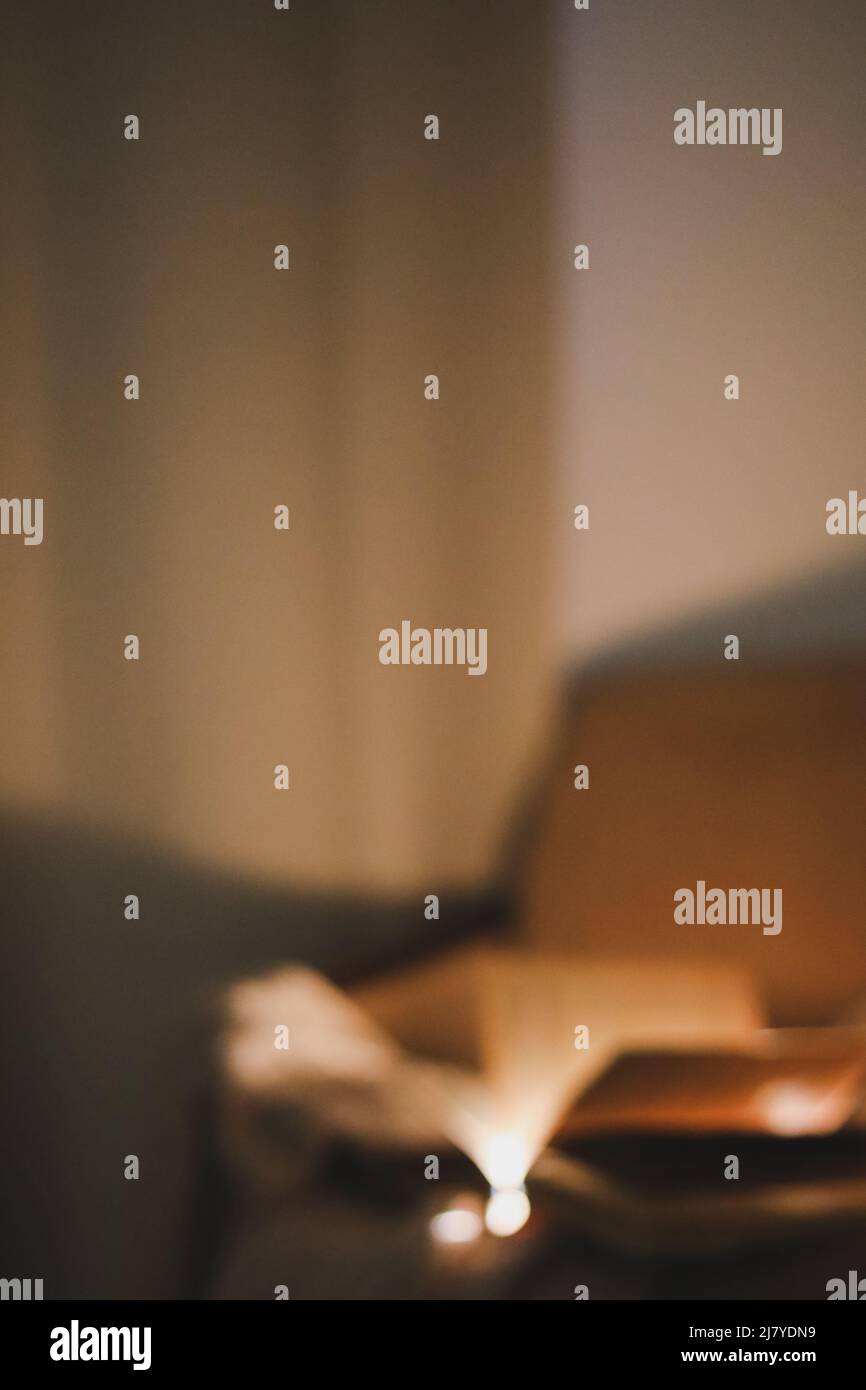 Cozy warm aesthetic evening atmosphere with an open book and plaid ...