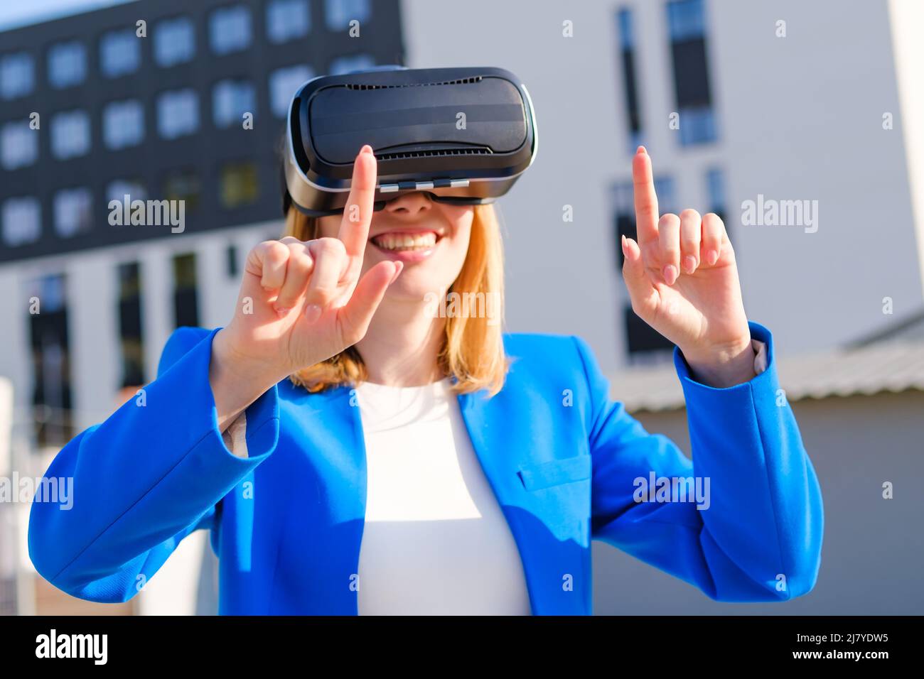 A happy woman in the suit is standing outside and gestures in augmented ...
