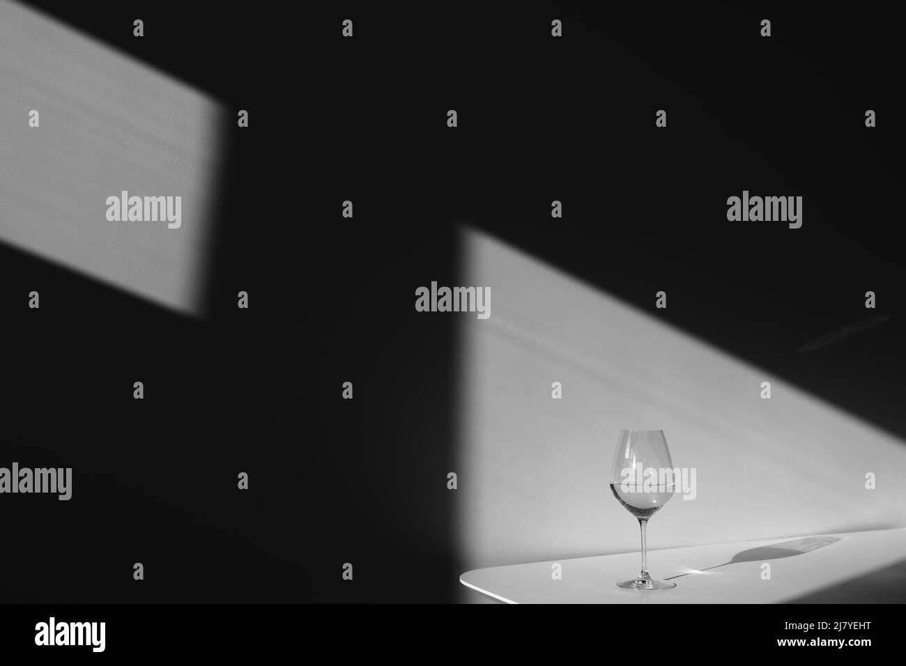 A glass of water on a white background with a shadow. Chiaroscuro from ...