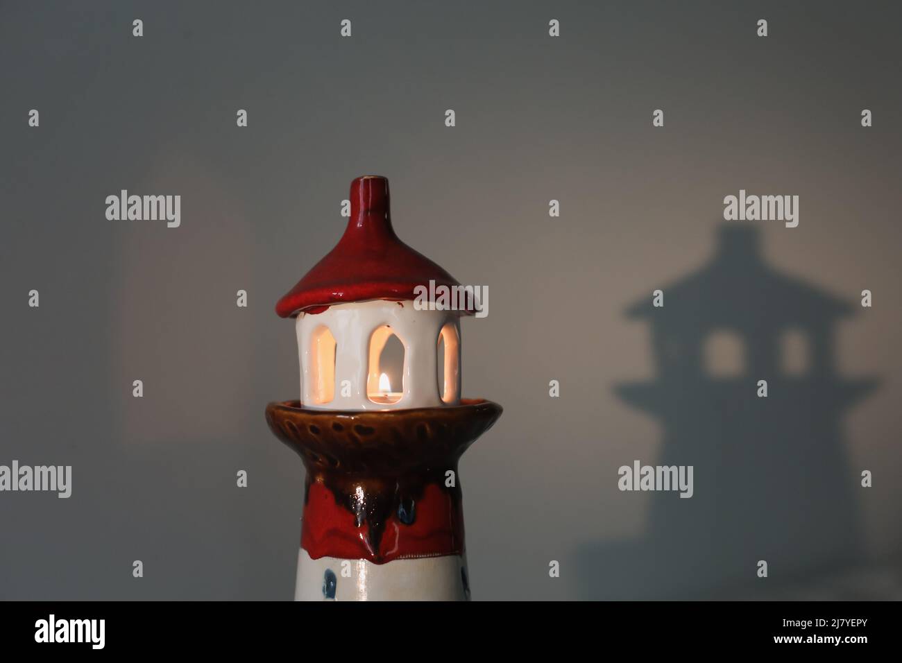 burning candle in a candlestick in the shape of a lighthouse Stock ...