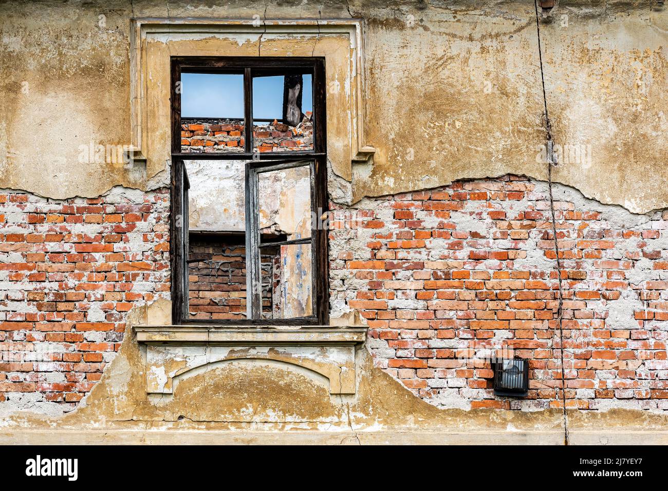 An old broken window in the chipped wall of the building to be ...