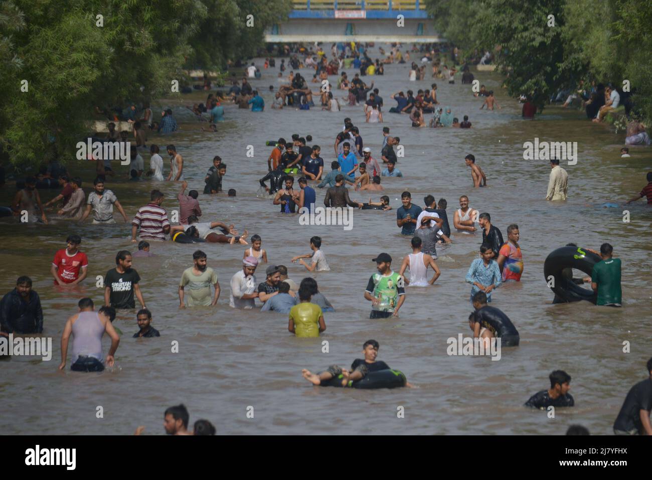 Pakistani people cool off in a canal during hot weather in Lahore ...
