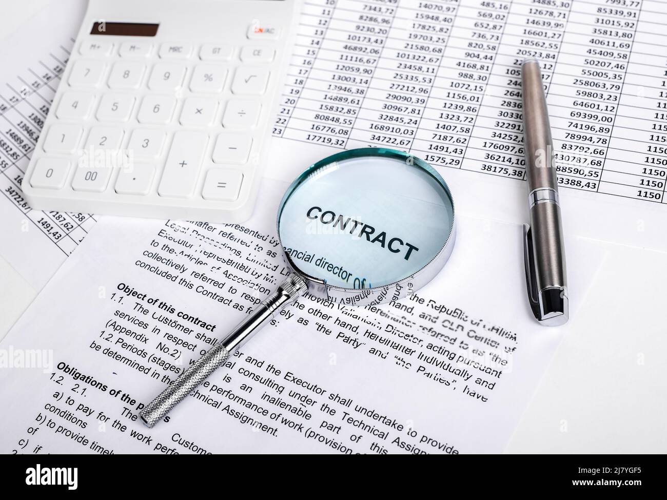 Contract with magnifier, calculator and pen. Careful reading, analysis ...