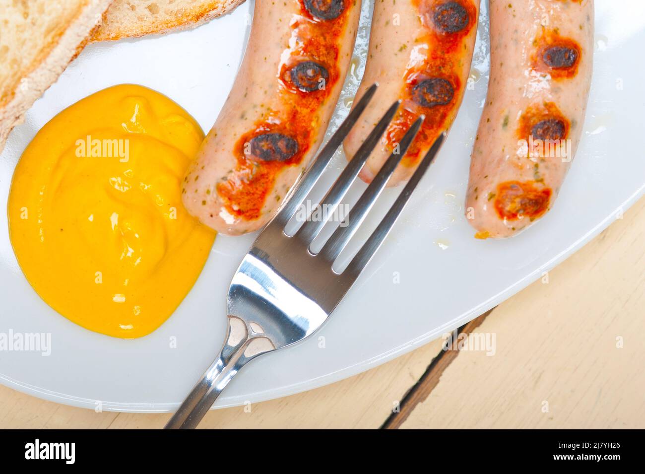 traditional fresh German wurstel sausages grilled with yellow mustard ...