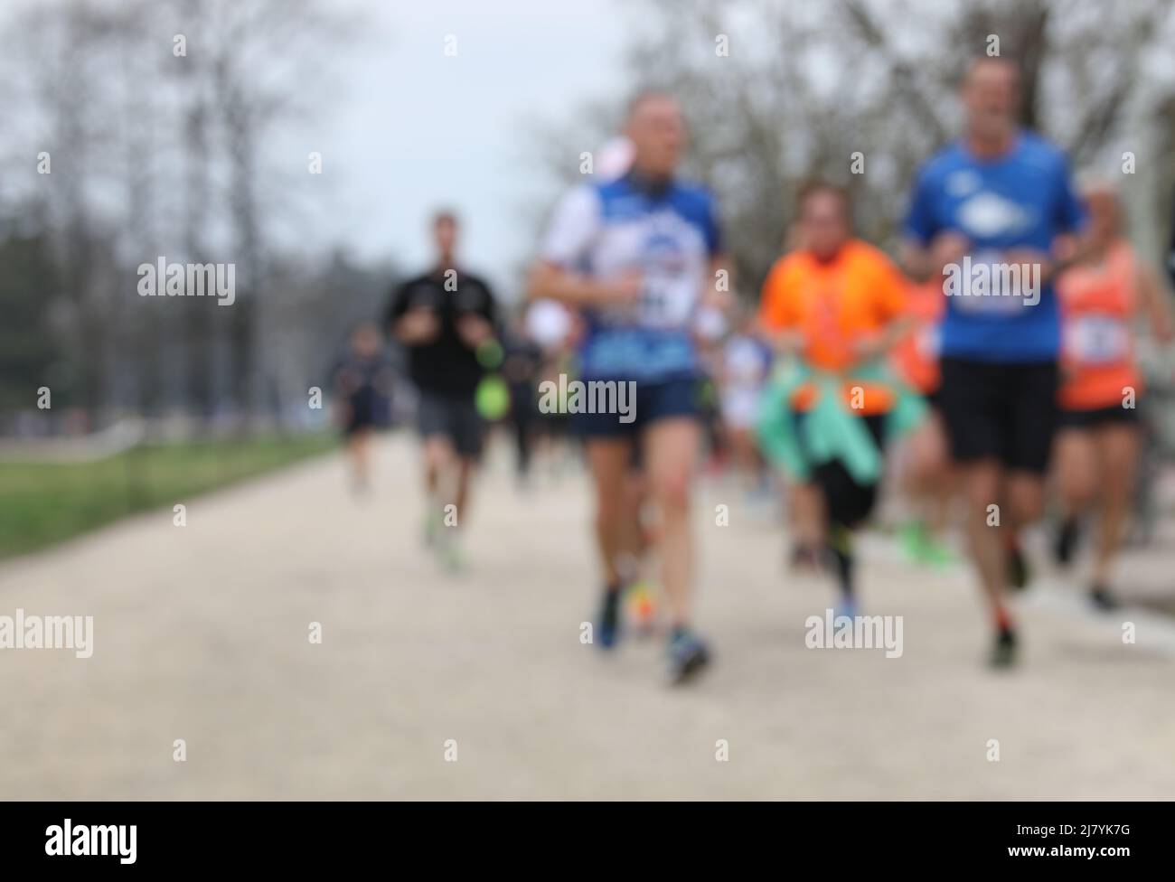 Intentionally blurred group of athletes running in the public park ...