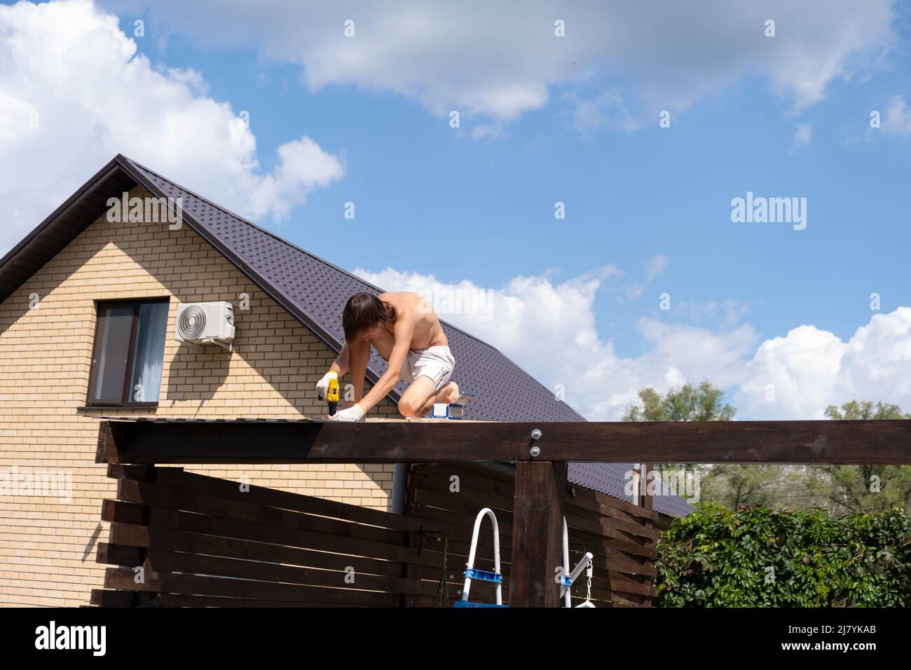 Building roof. Young men repair roof. Roof construction. Working at ...