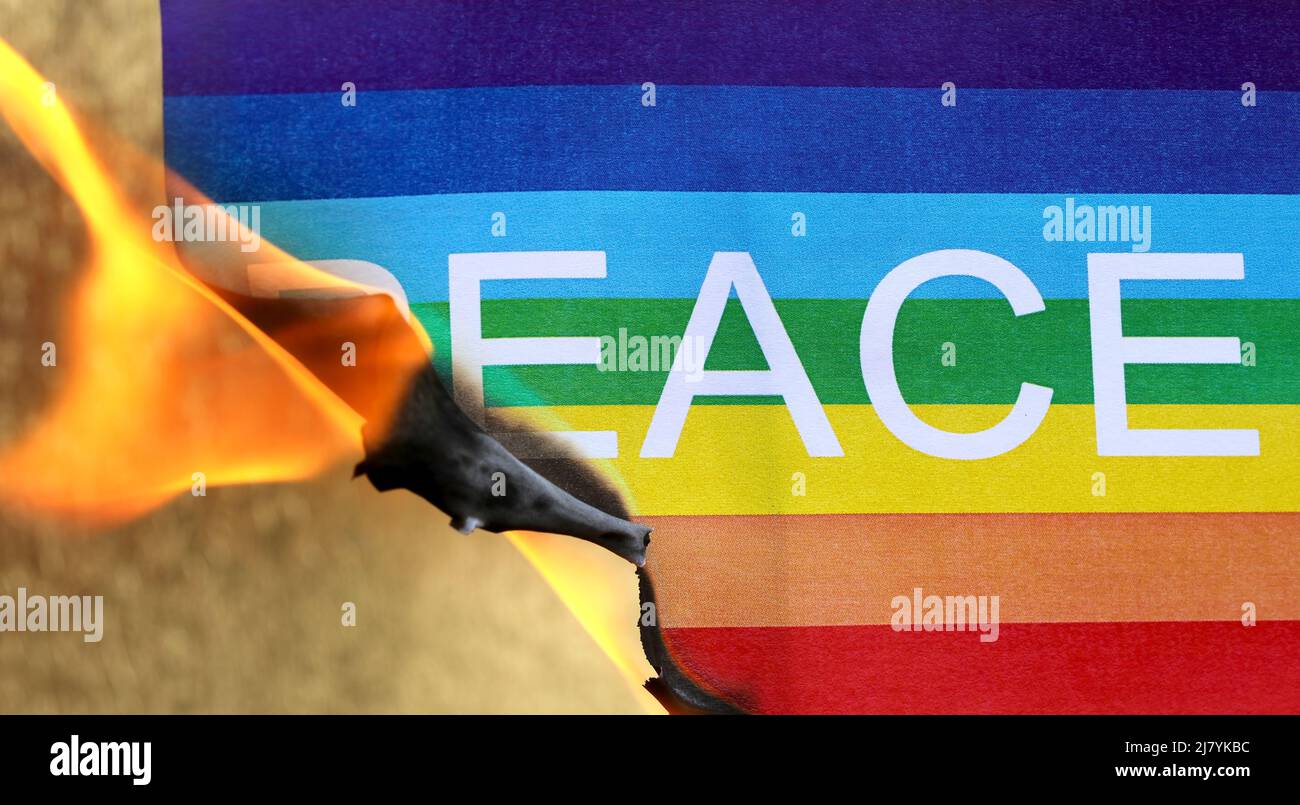 Peace flag with rainbow colors burning with fire flame and golden ...