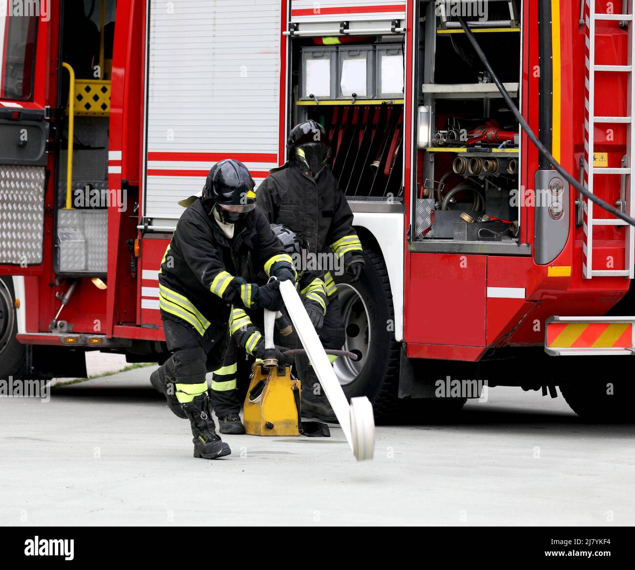 firefighter carrying out the launch of the rolled up hose during the ...