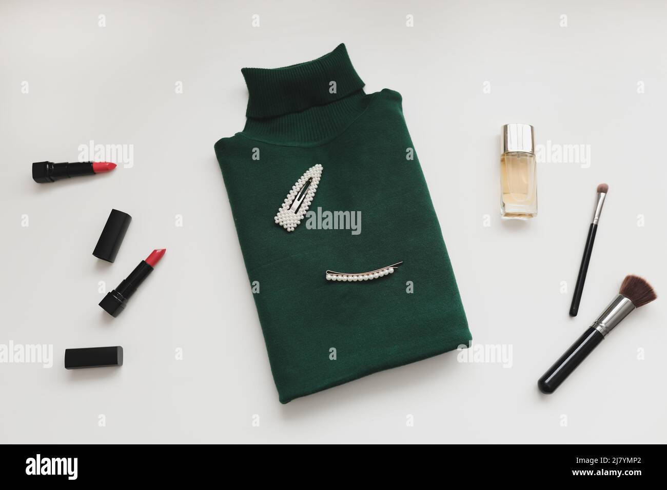 Overhead view of women's knitted sweater, perfume and accessories on ...