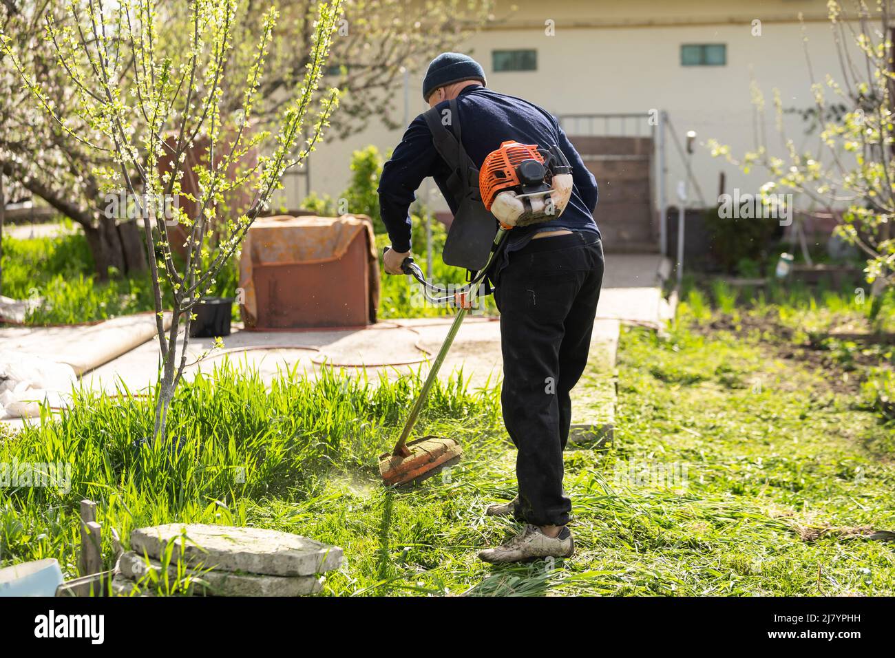 farmer mowing green grass with a scythe in the field Stock Photo - Alamy