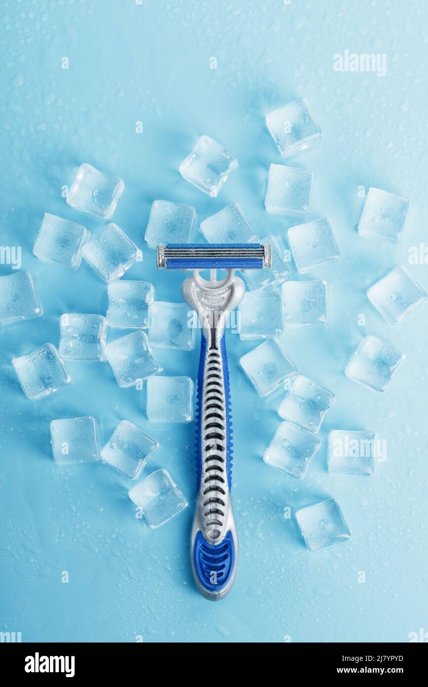 Shaving machine on a blue background with ice cubes. The concept of ...