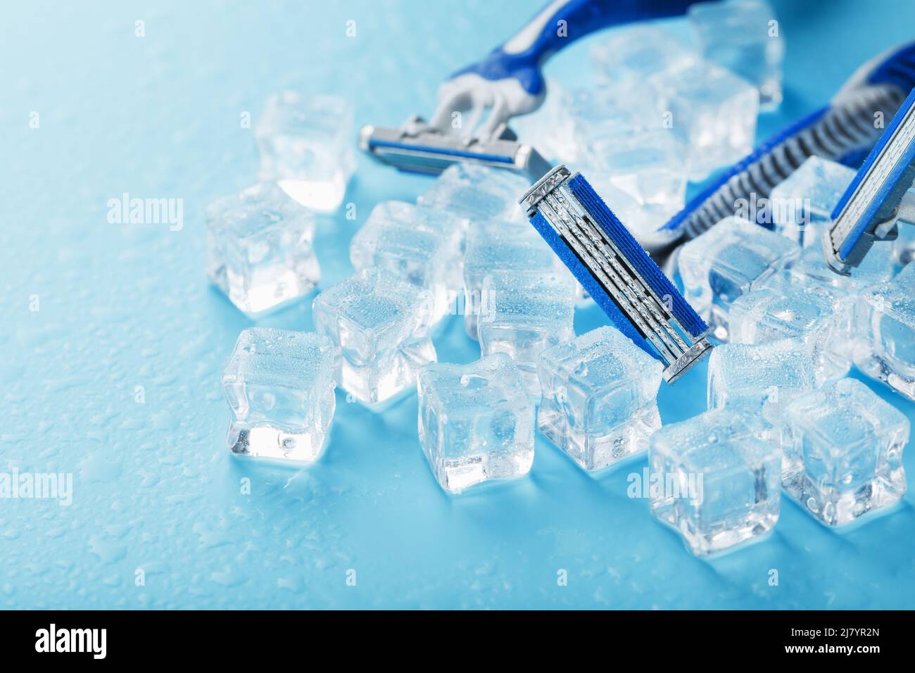 Shaving machine on a blue background with ice cubes. The concept of ...