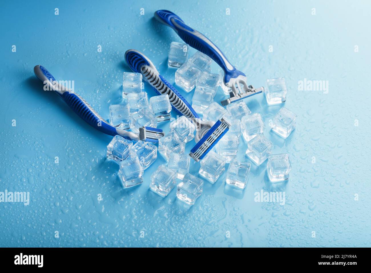 Shaving machine on a blue background with ice cubes. The concept of ...