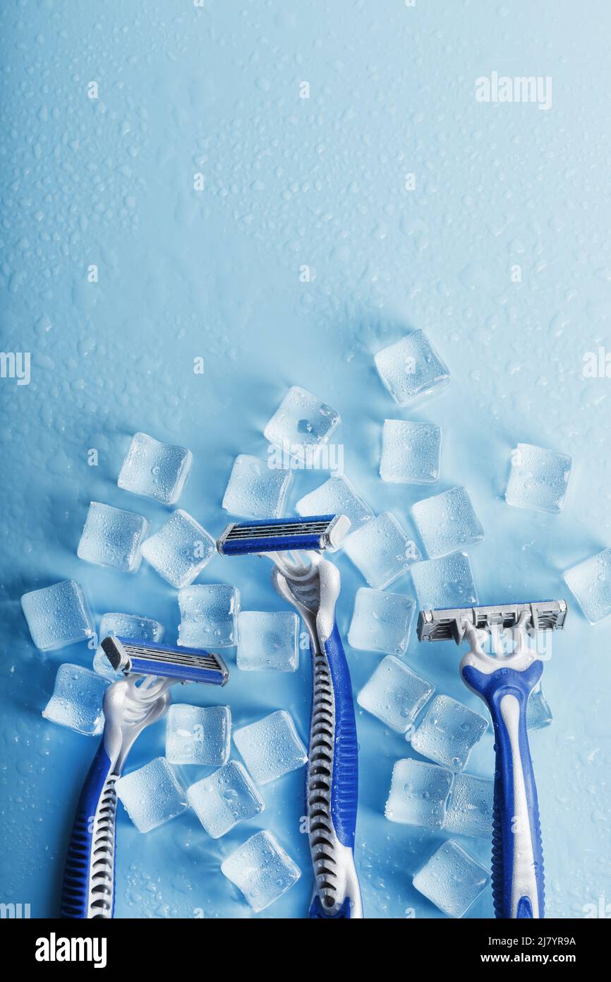 Shaving machine on a blue background with ice cubes. The concept of ...