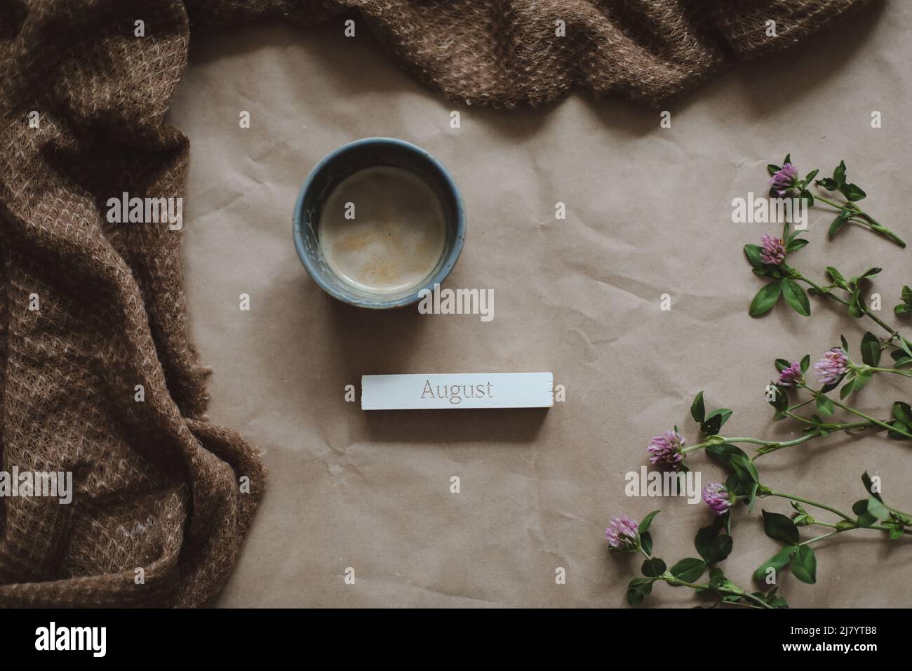 Hello August concept. Brown paper texture background with flowers, top ...