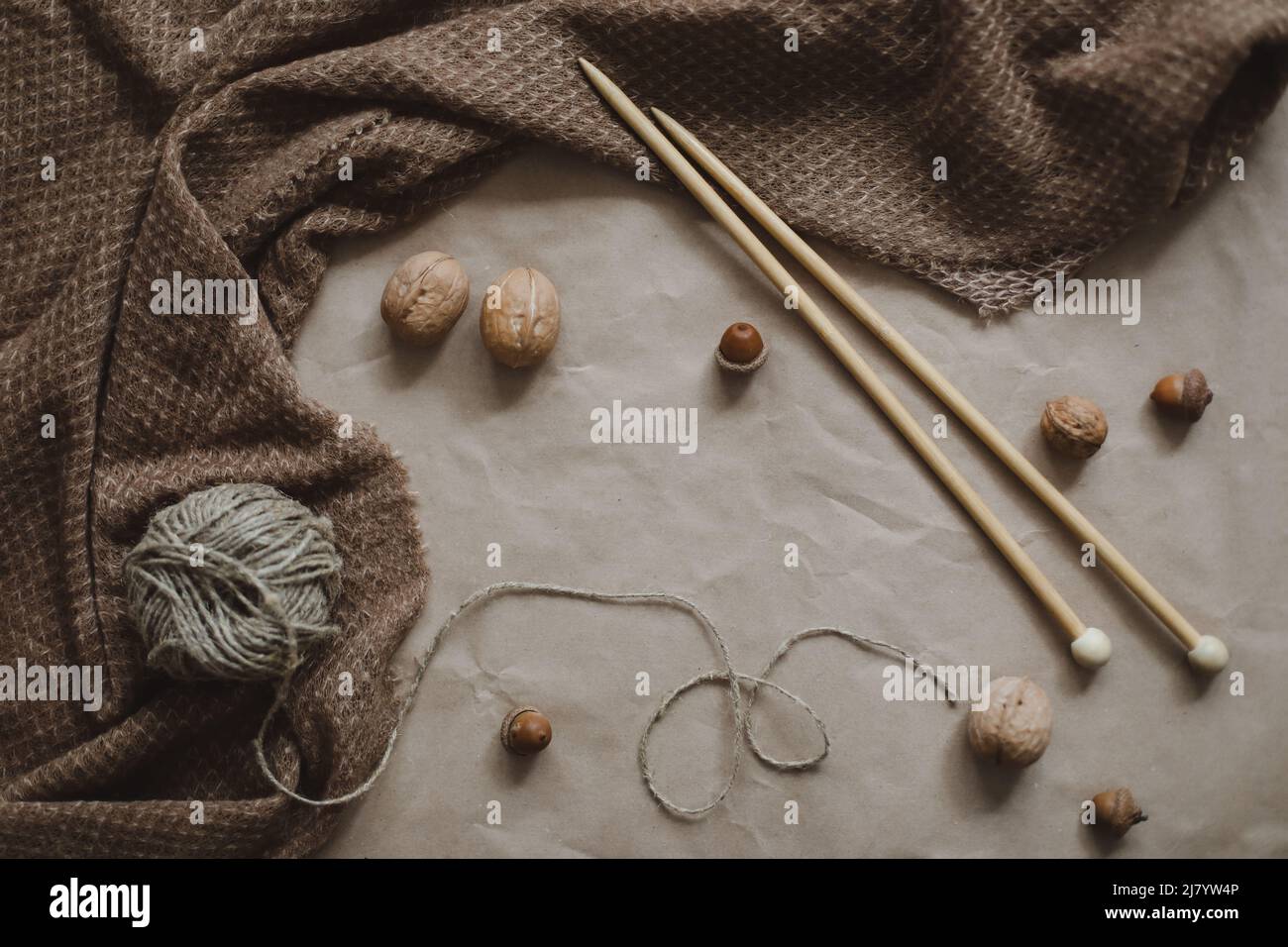 Hobby, leisure theme. Yarn and wooden needles on a brown paper texture ...