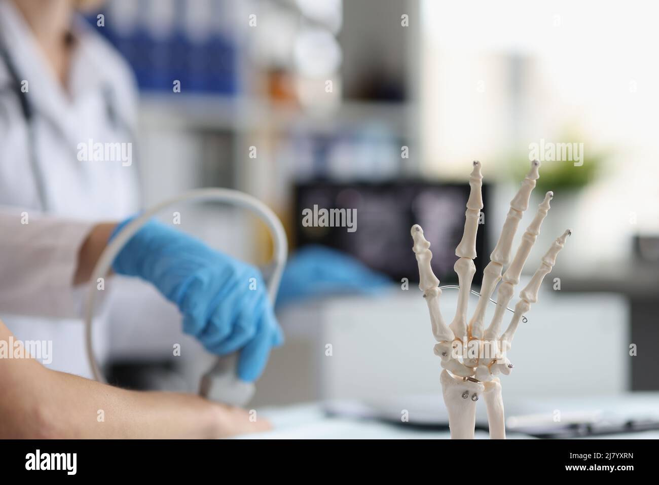 Doctor do ultrasound of hand, skeleton hand model on desk, medical ...