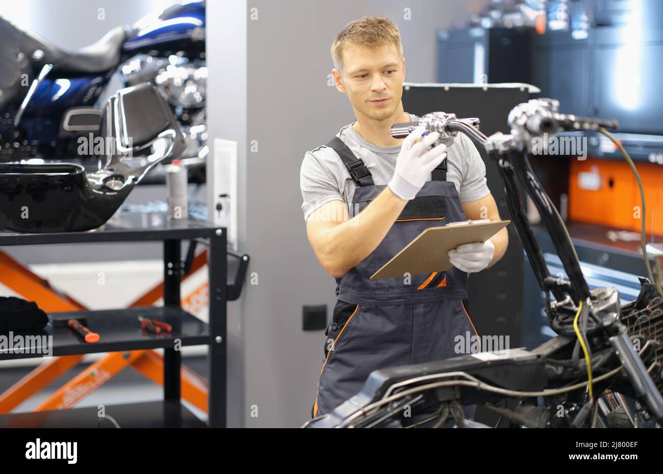 Maintenance service worker in uniform examine motorbike, man with ...