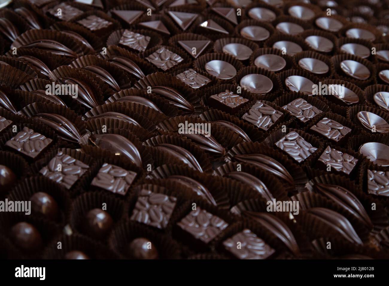 Lots of handmade chocolate candies with filling in a chocolate factory ...