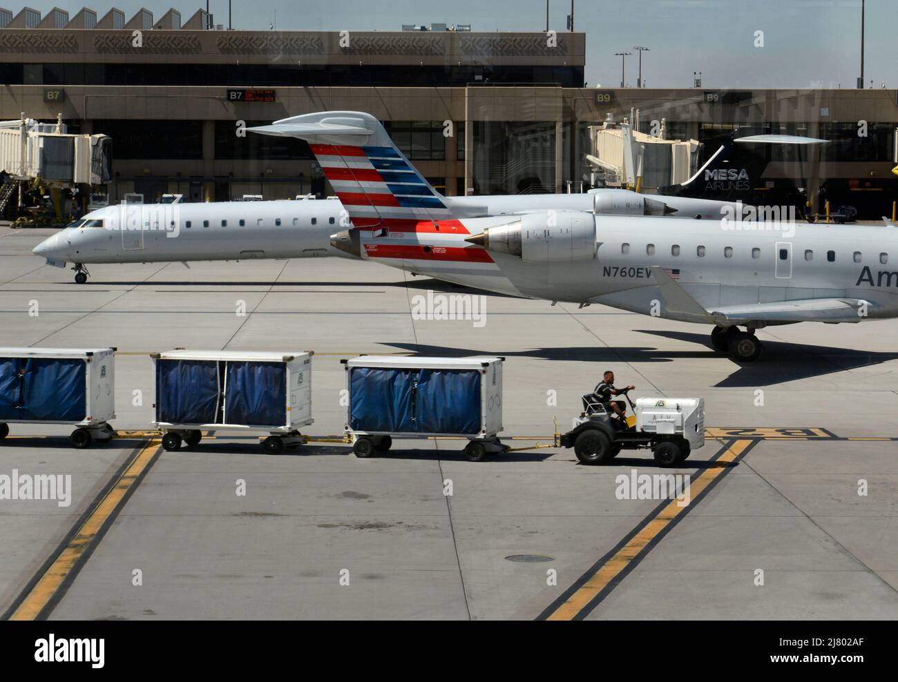 Ground crew members work on the tarmac as American Airlines and ...
